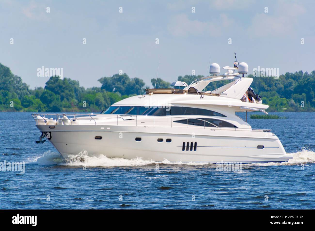 Close-up of white luxury yacht in motion on the Dniepr River, side view ...