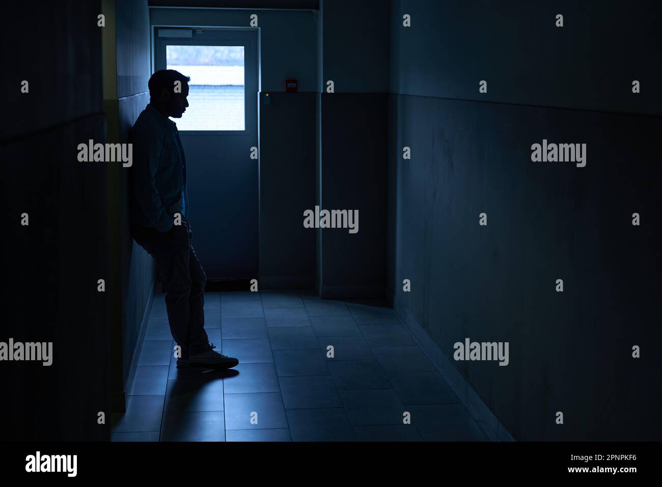 Figure of man standing in darkness and waiting Stock Photo - Alamy