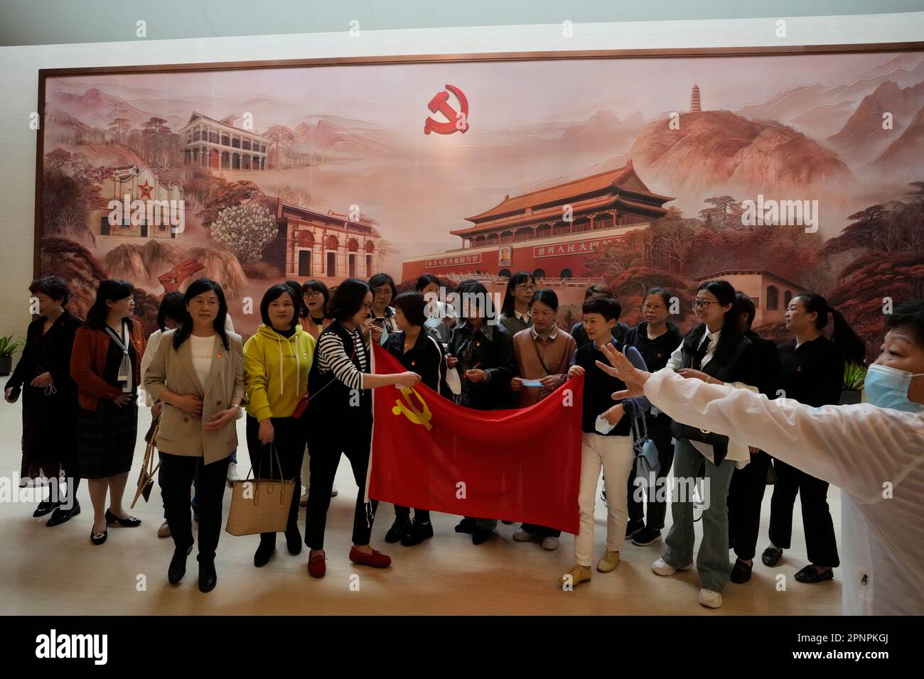 Visitors take photos with the Chinese Communist Party flag at the ...