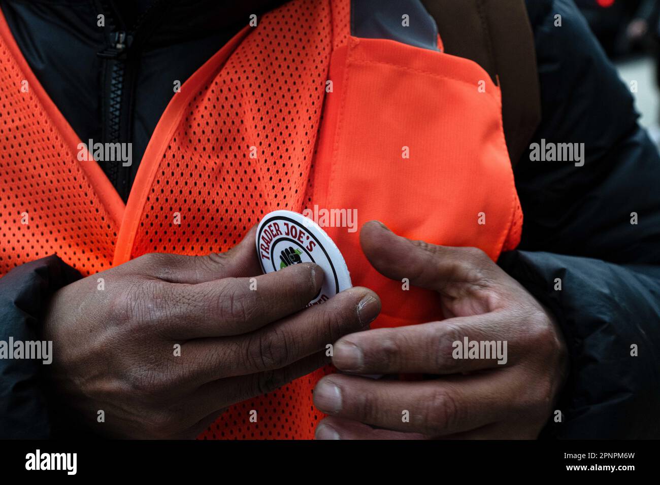 New York, New York, USA. 18th Apr, 2023. A worker pins a union badge as ...