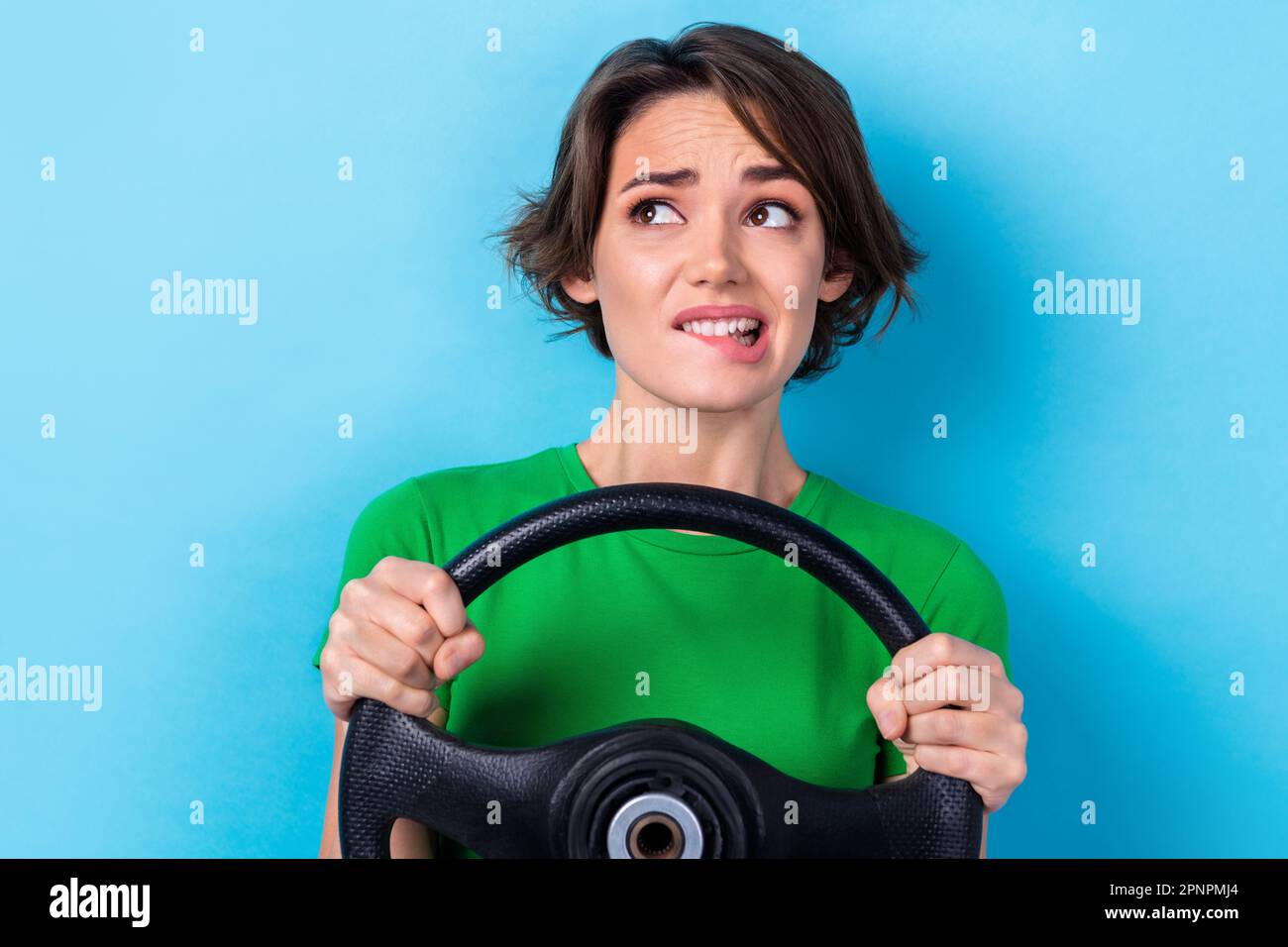 Closeup photo of young girl bite lips hold steering wheel driving car ...