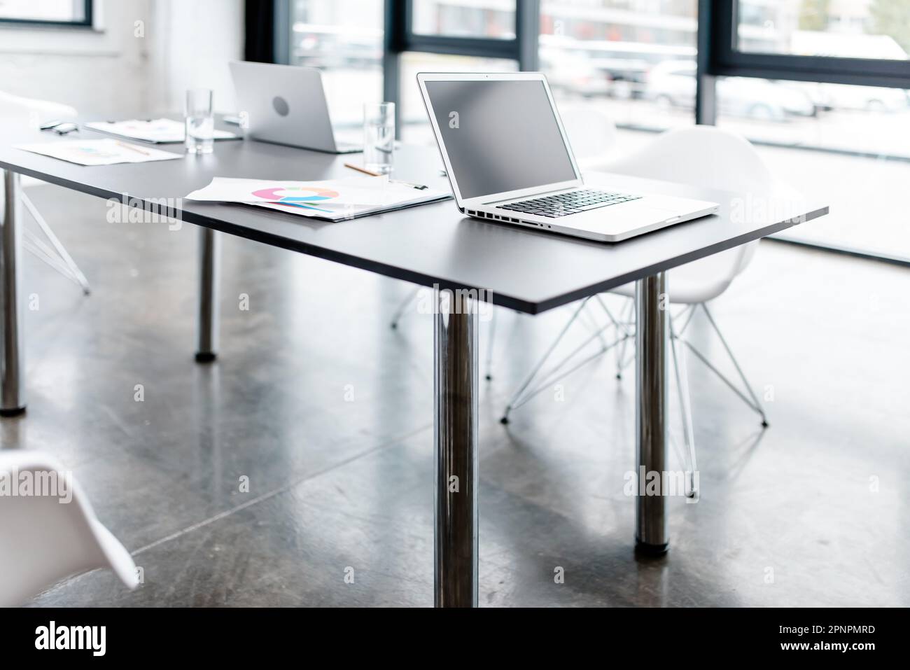 Modern office with graph sheets and laptop on a desk Stock Photo - Alamy