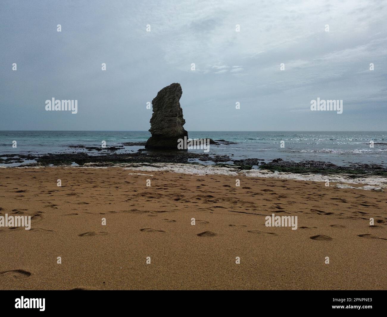 A solitary rock on a beach shore Stock Photo - Alamy