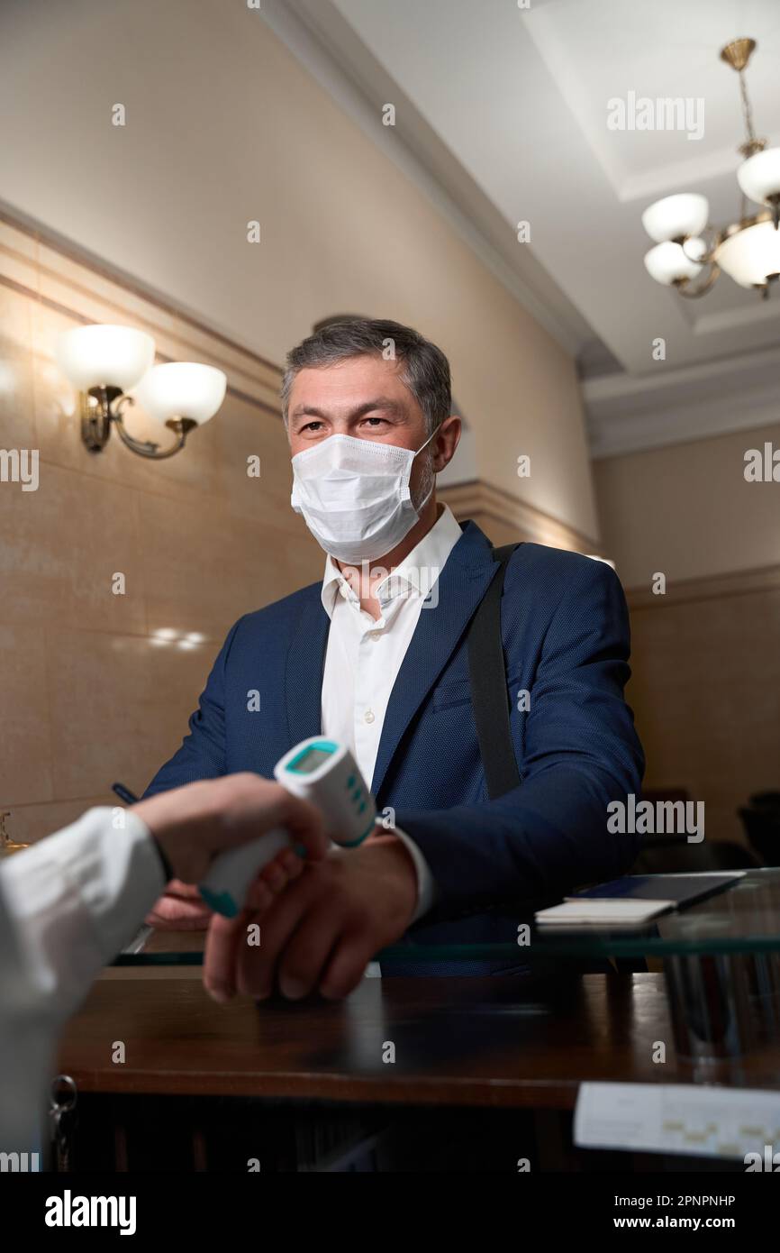 Portrait of adult male came to hotel, checking temperature Stock Photo ...