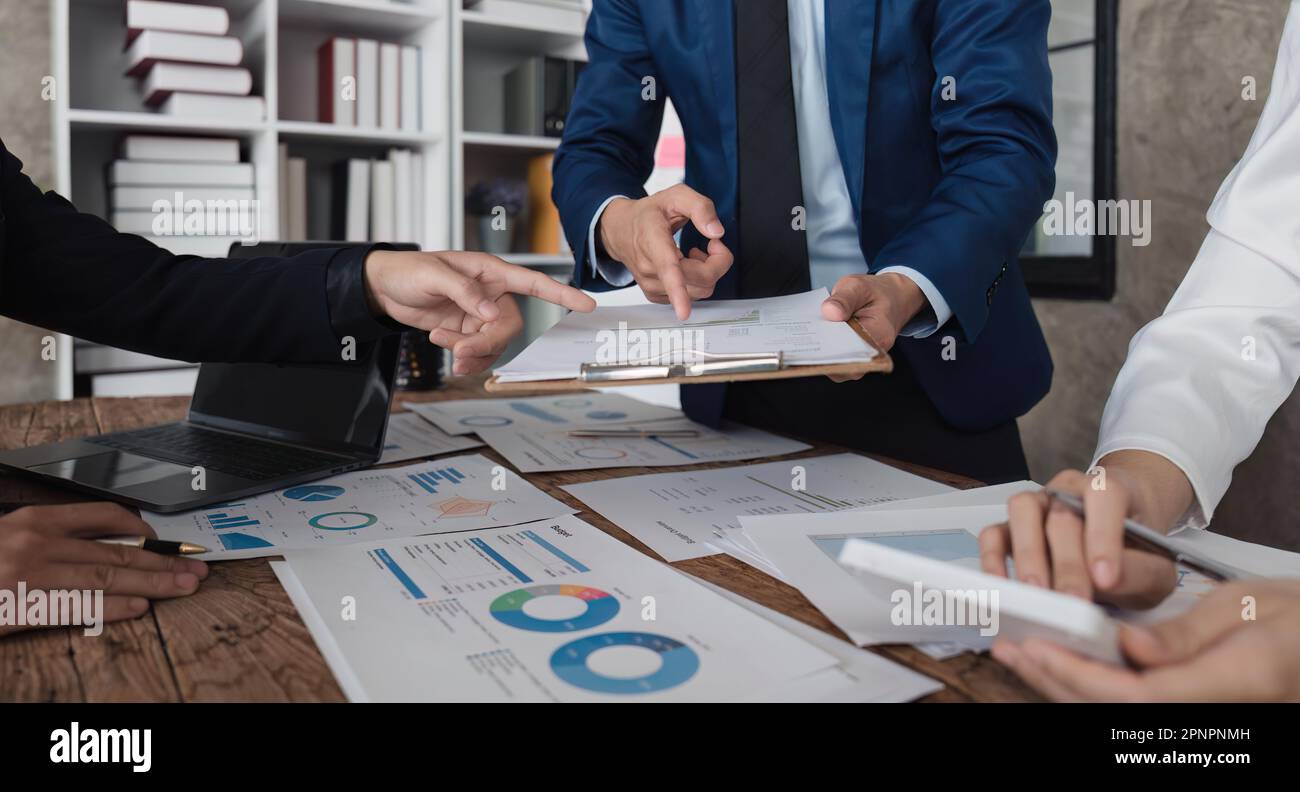 Business team using a calculator to calculate the numbers of statistic ...