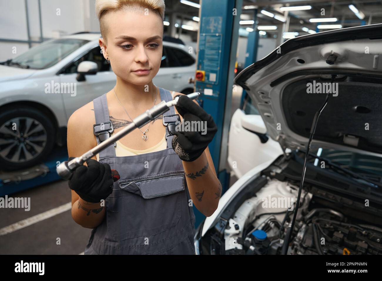 Blond woman repairing auto in detailing service Stock Photo - Alamy