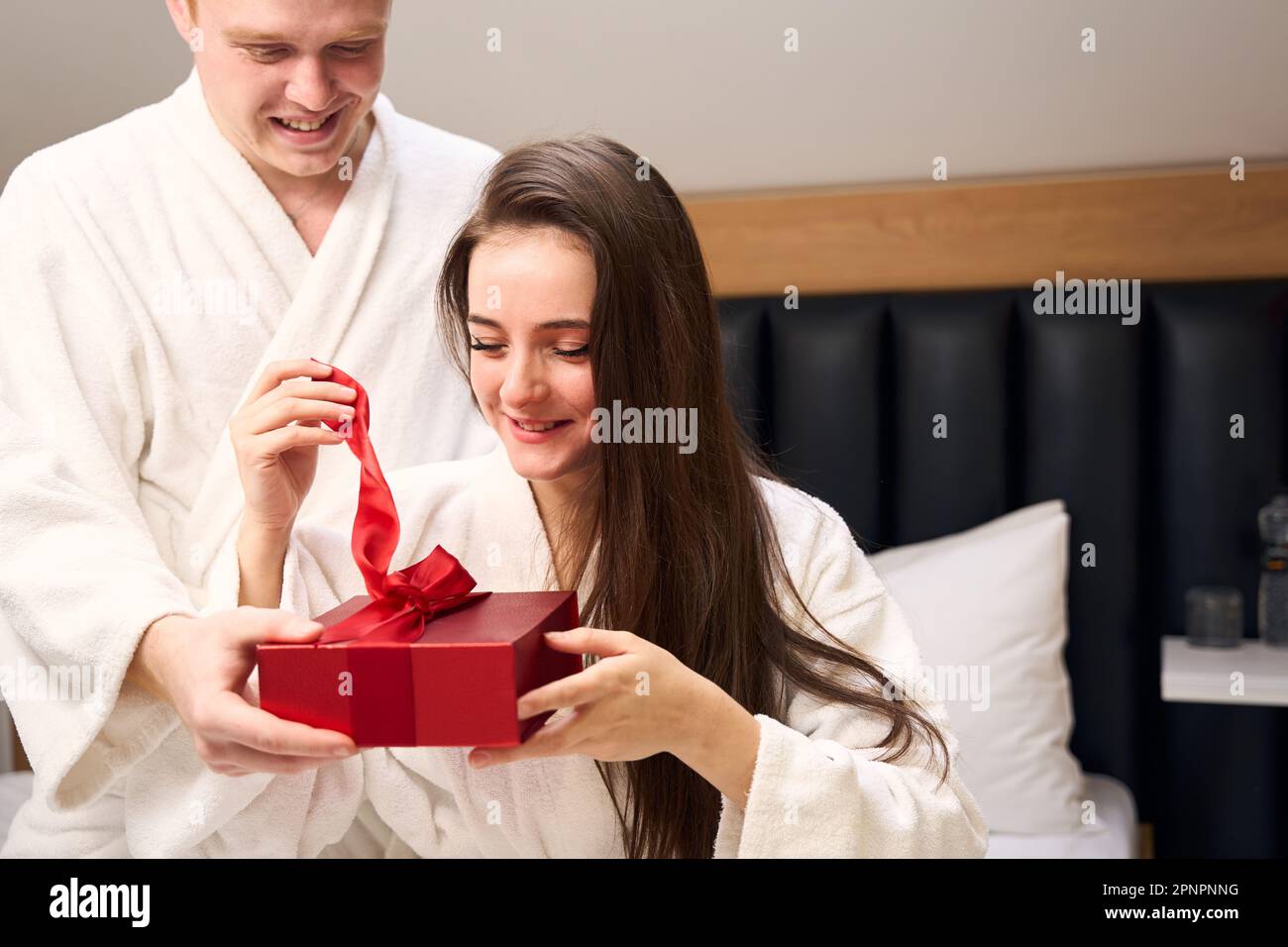 Charming woman opens a box with a gift Stock Photo - Alamy