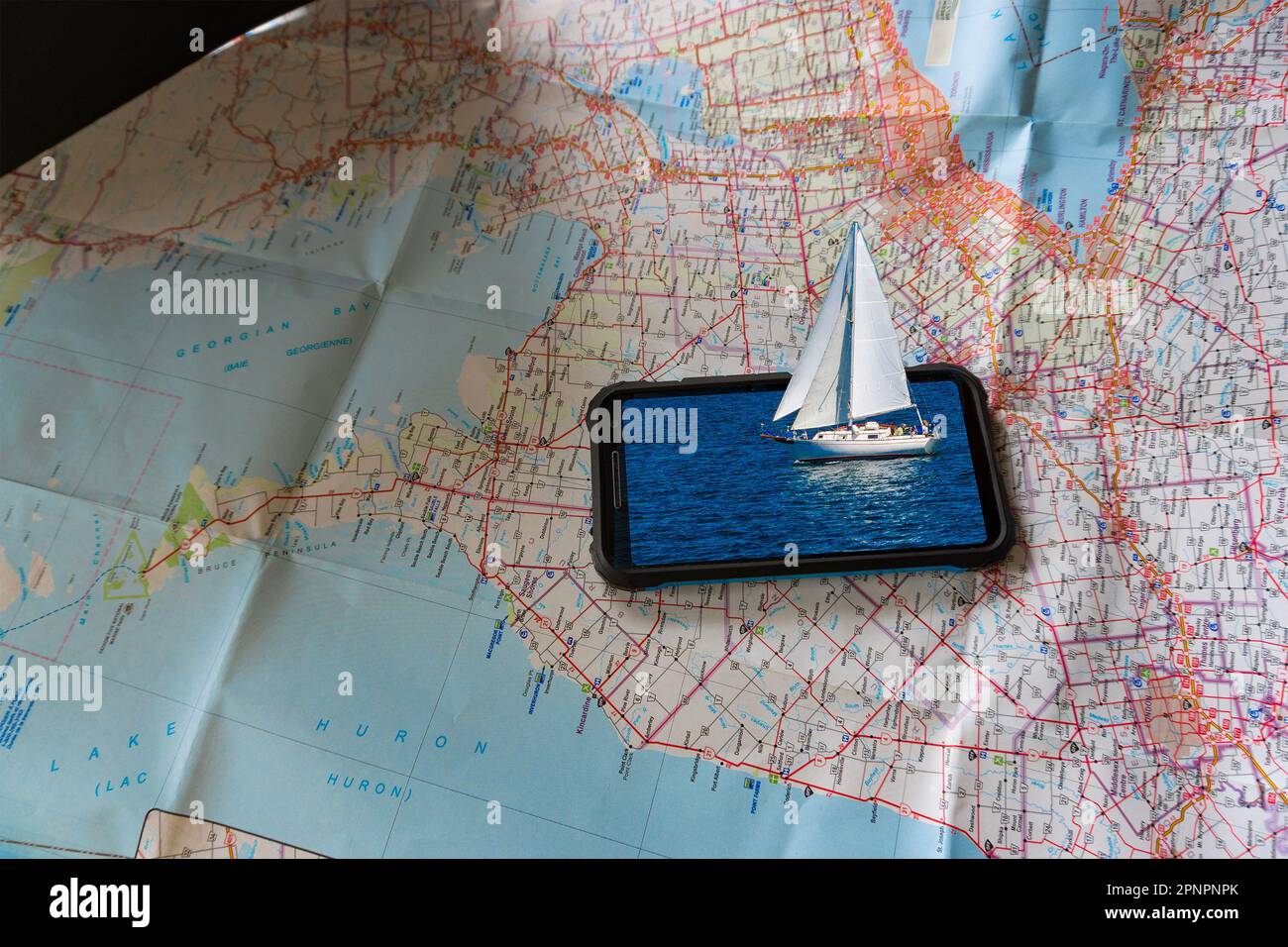 iPhone with a floating sailboat on the background of a map with lakes ...
