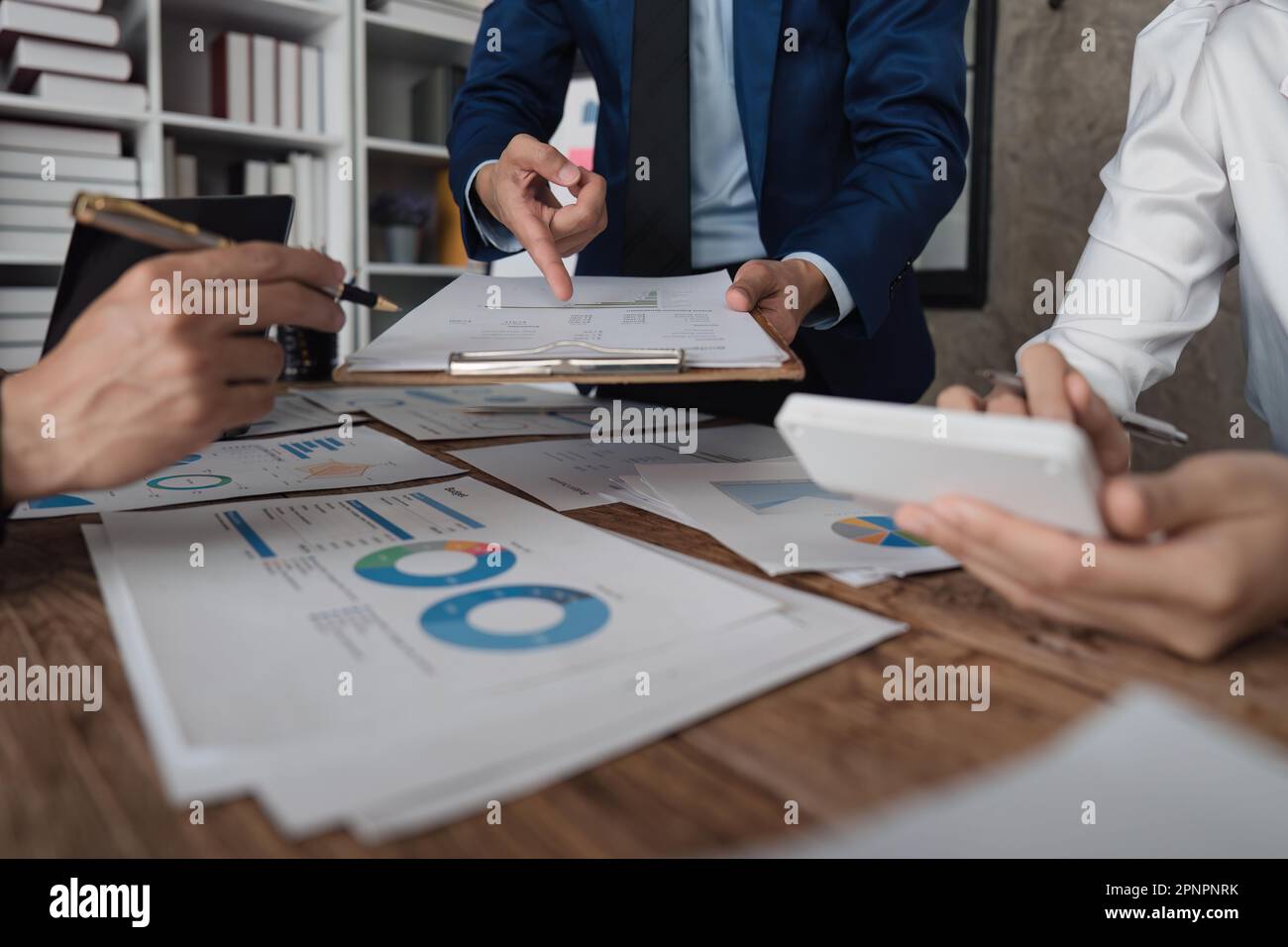 Business team using a calculator to calculate the numbers of statistic ...