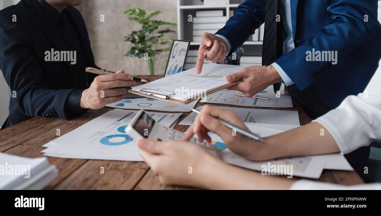 Business team using a calculator to calculate the numbers of statistic ...