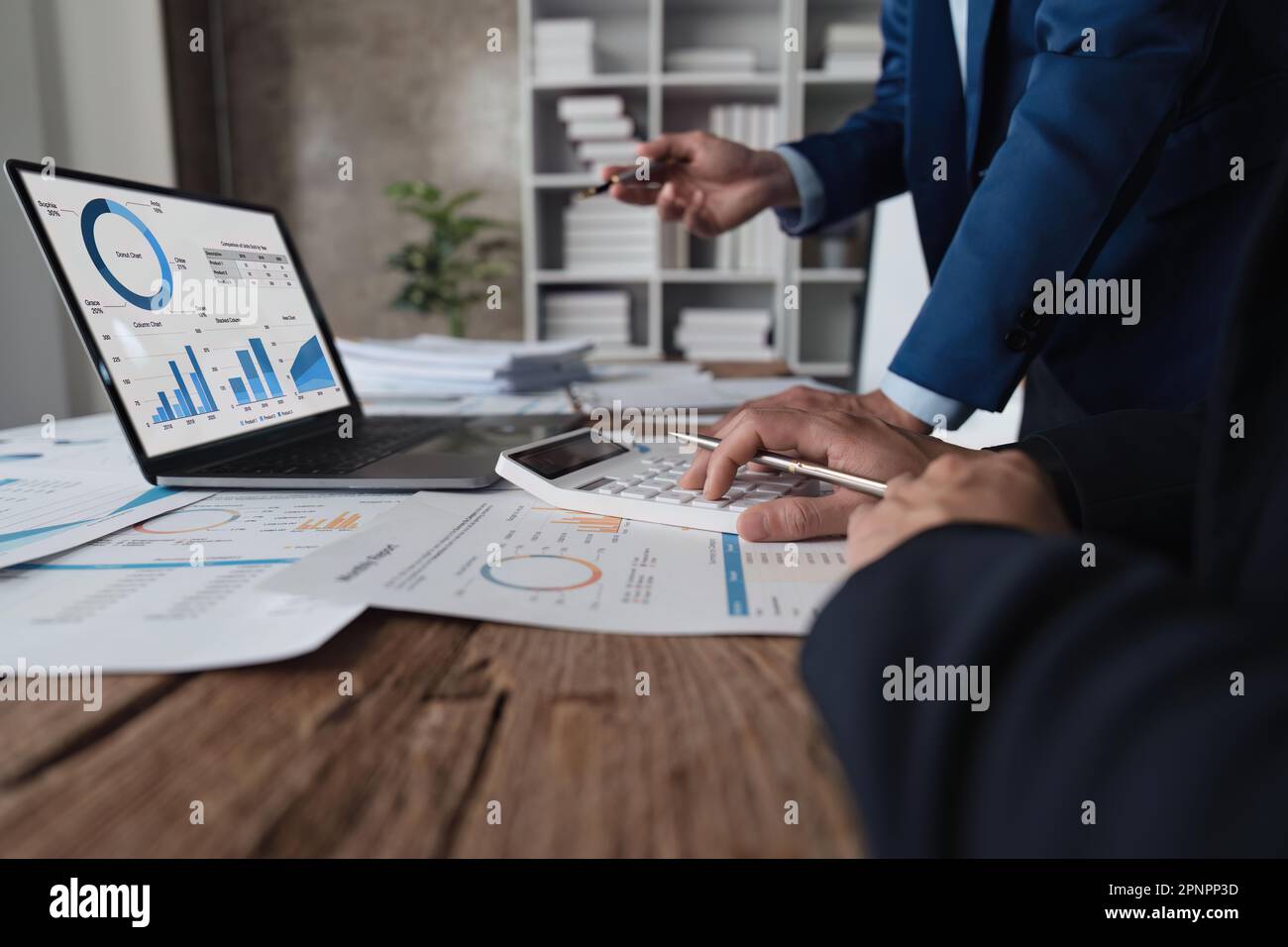 Business team using a calculator to calculate the numbers of statistic ...