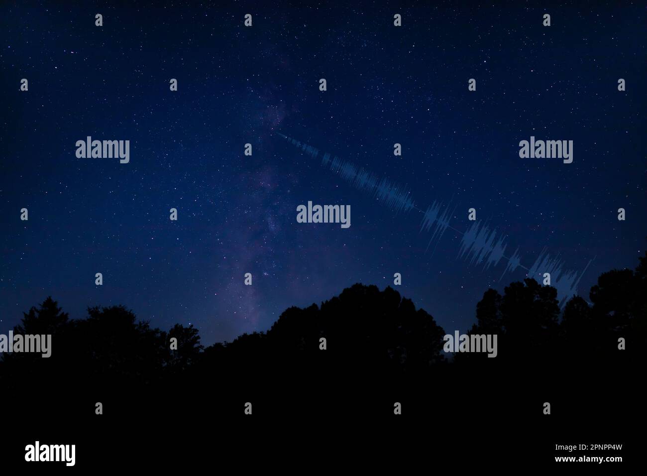 Signal beaming in from space and disappearing behind a forest atnight ...