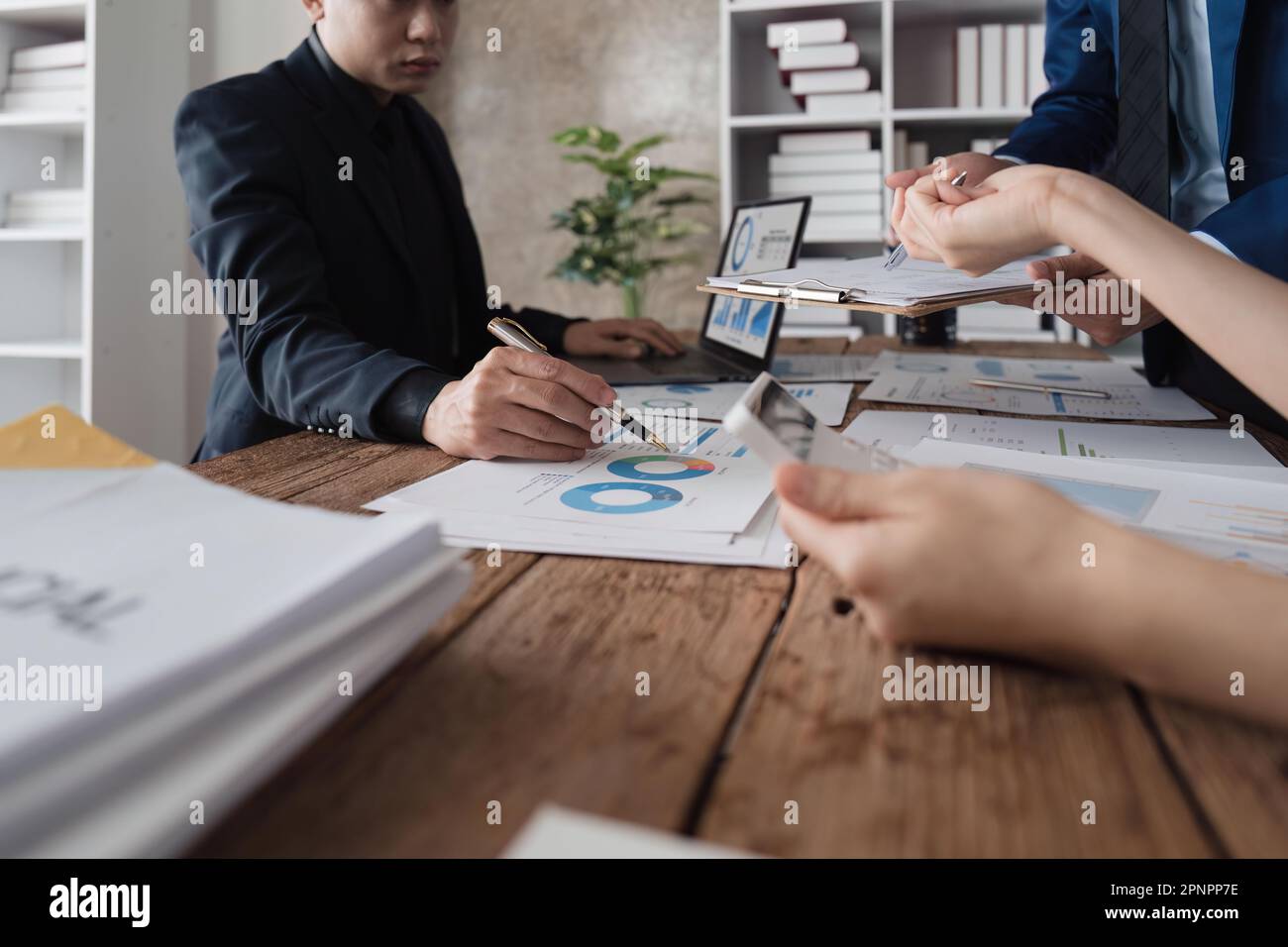 Business team using a calculator to calculate the numbers of statistic ...