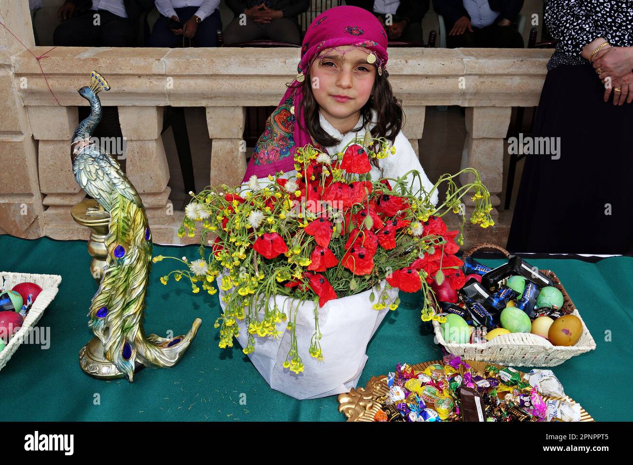 A girl in traditional clothes greets guests with an Angel Tawus ...