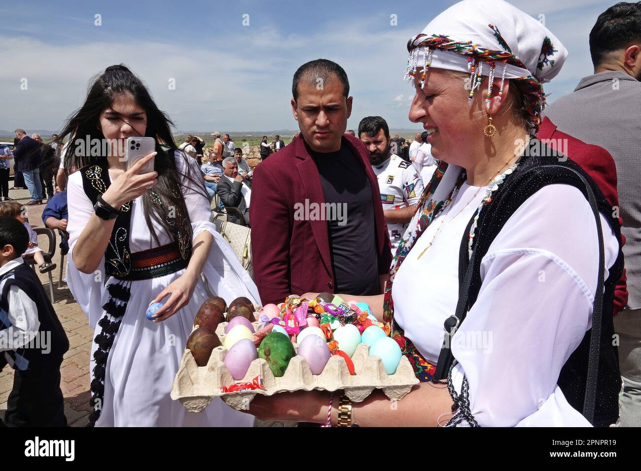 A Yazidi woman is seen handing out painted eggs to guests during the ...