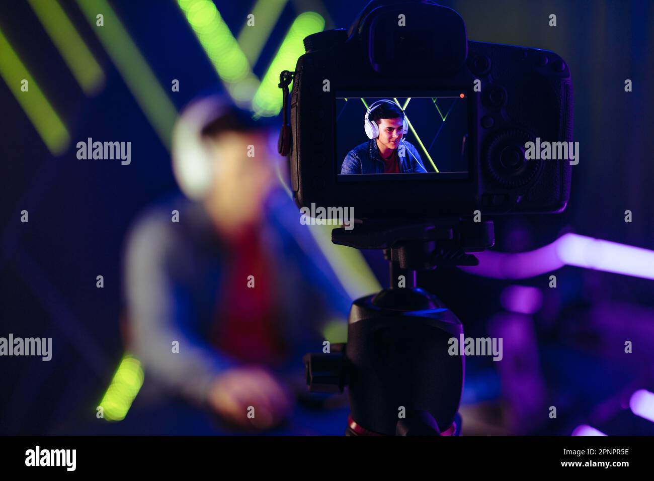 Gamer, sitting in front of a computer screen, live streams his gaming ...