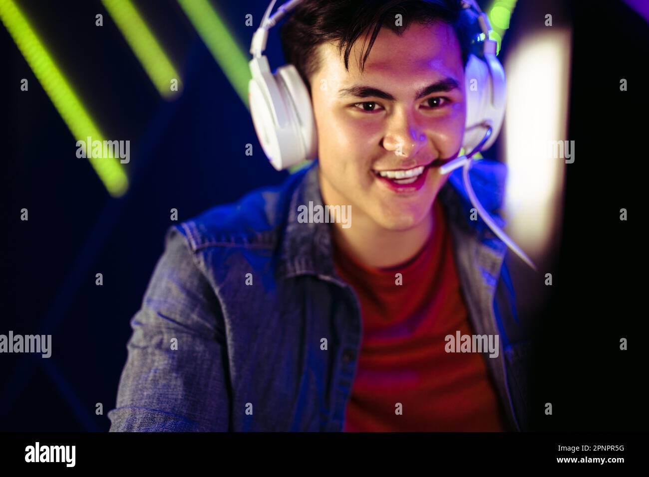 Male gamer sporting a smile as he looks at his computer screen while ...