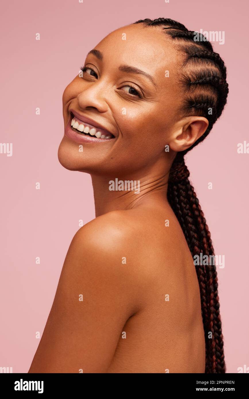 Attractive female model with glowing skin looking at camera and smiling ...