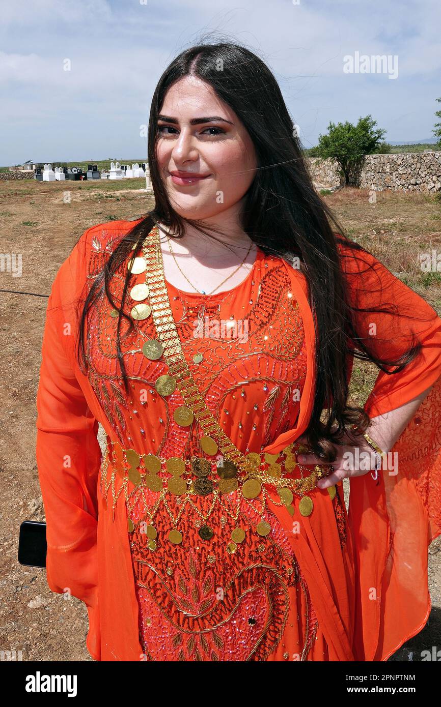 A Yazidi woman wearing colorful clothes participates in the celebration ...