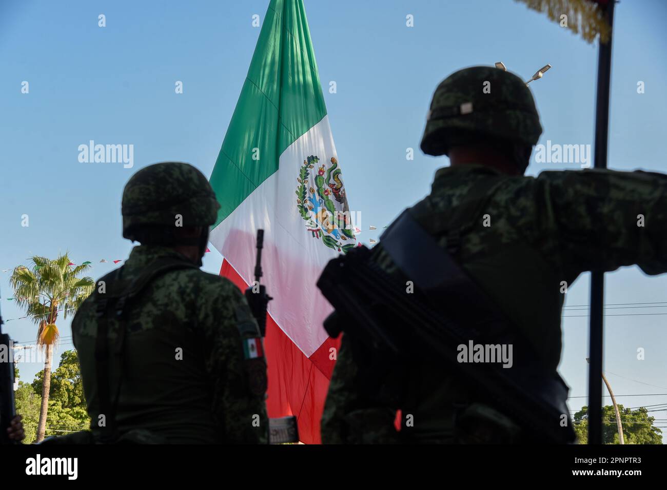 A group of uniformed Mexican military personnel march in formation ...