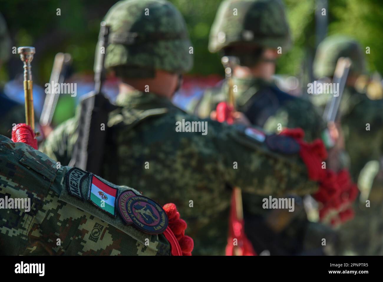 A group of uniformed Mexican military personnel march in formation ...