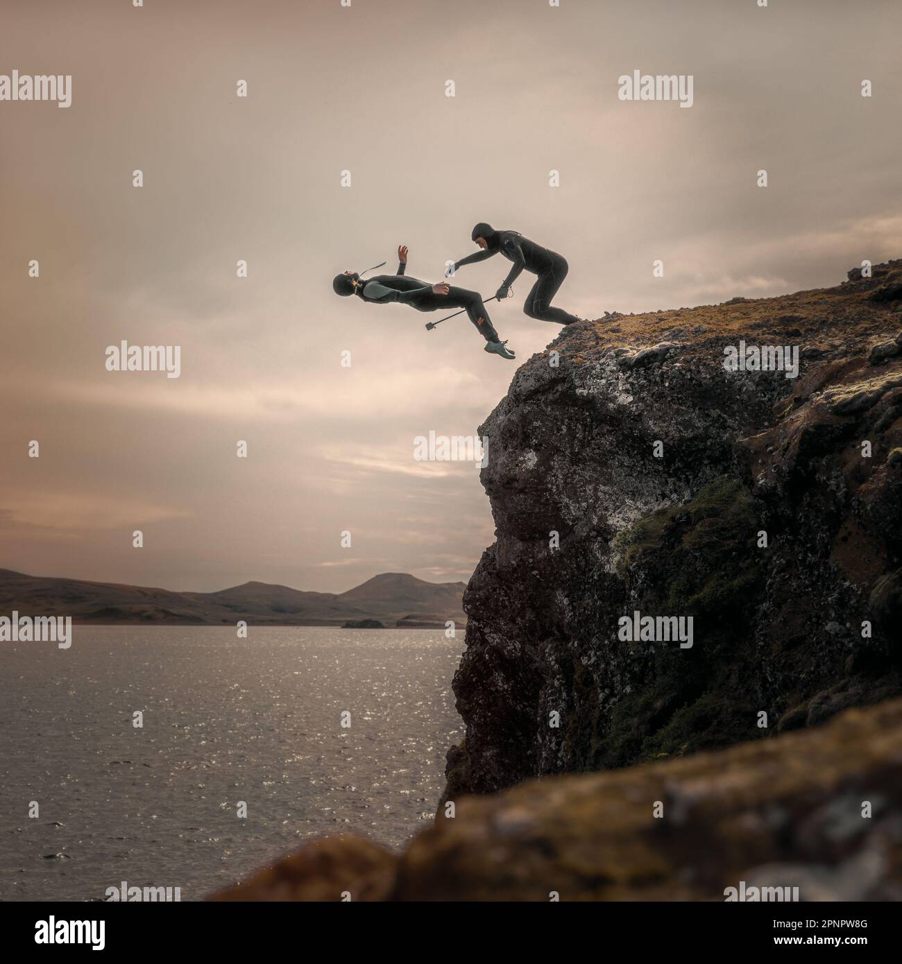 The two adult males cliff-jumping at sunset Stock Photo - Alamy