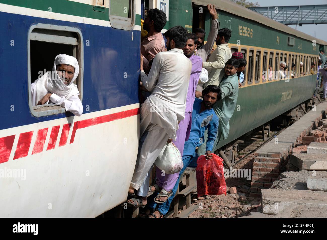People ride on an overcrowded passenger train to reach their villages ...