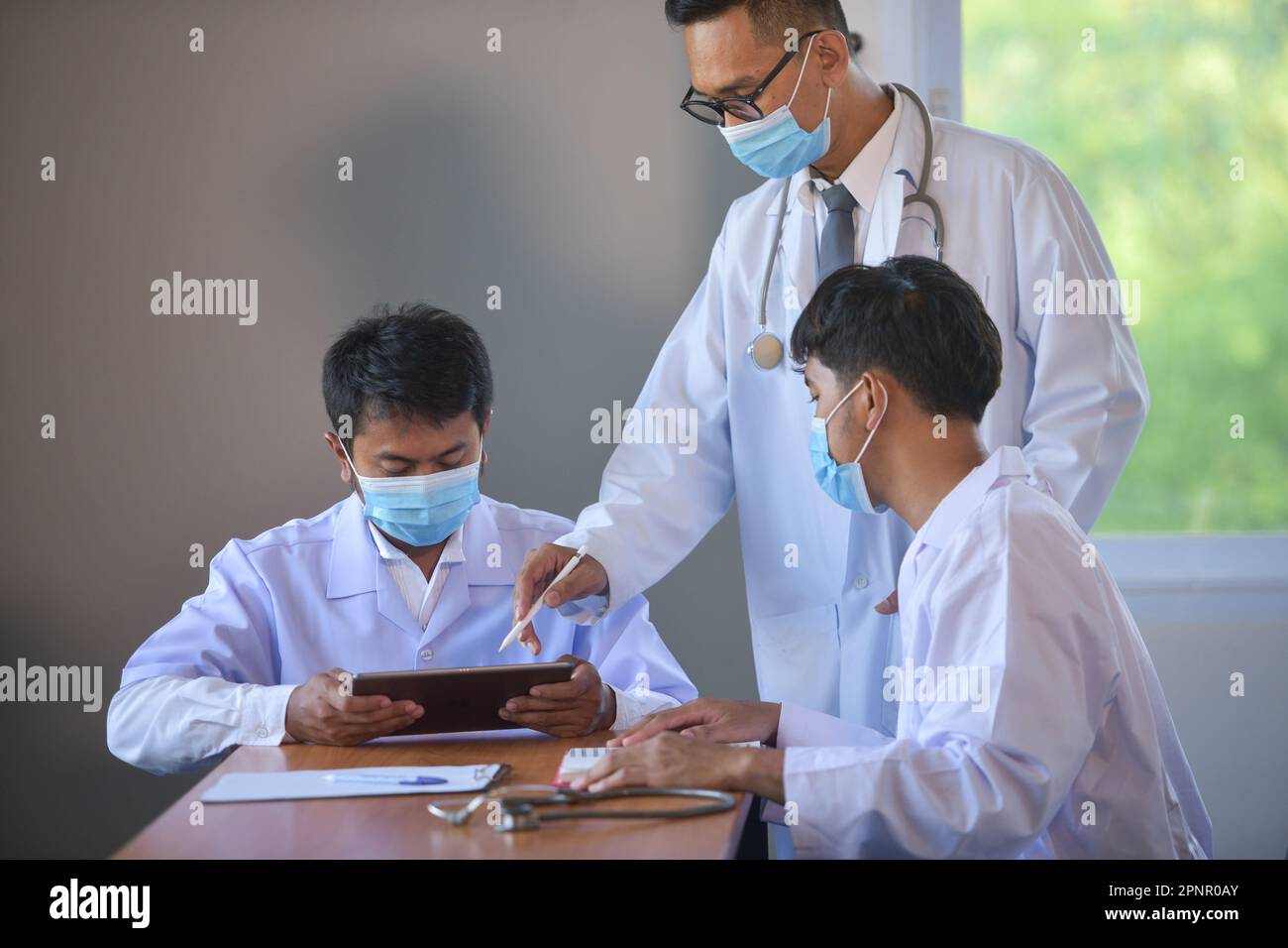 Three doctors having a consultation in a hospital meeting room Stock ...