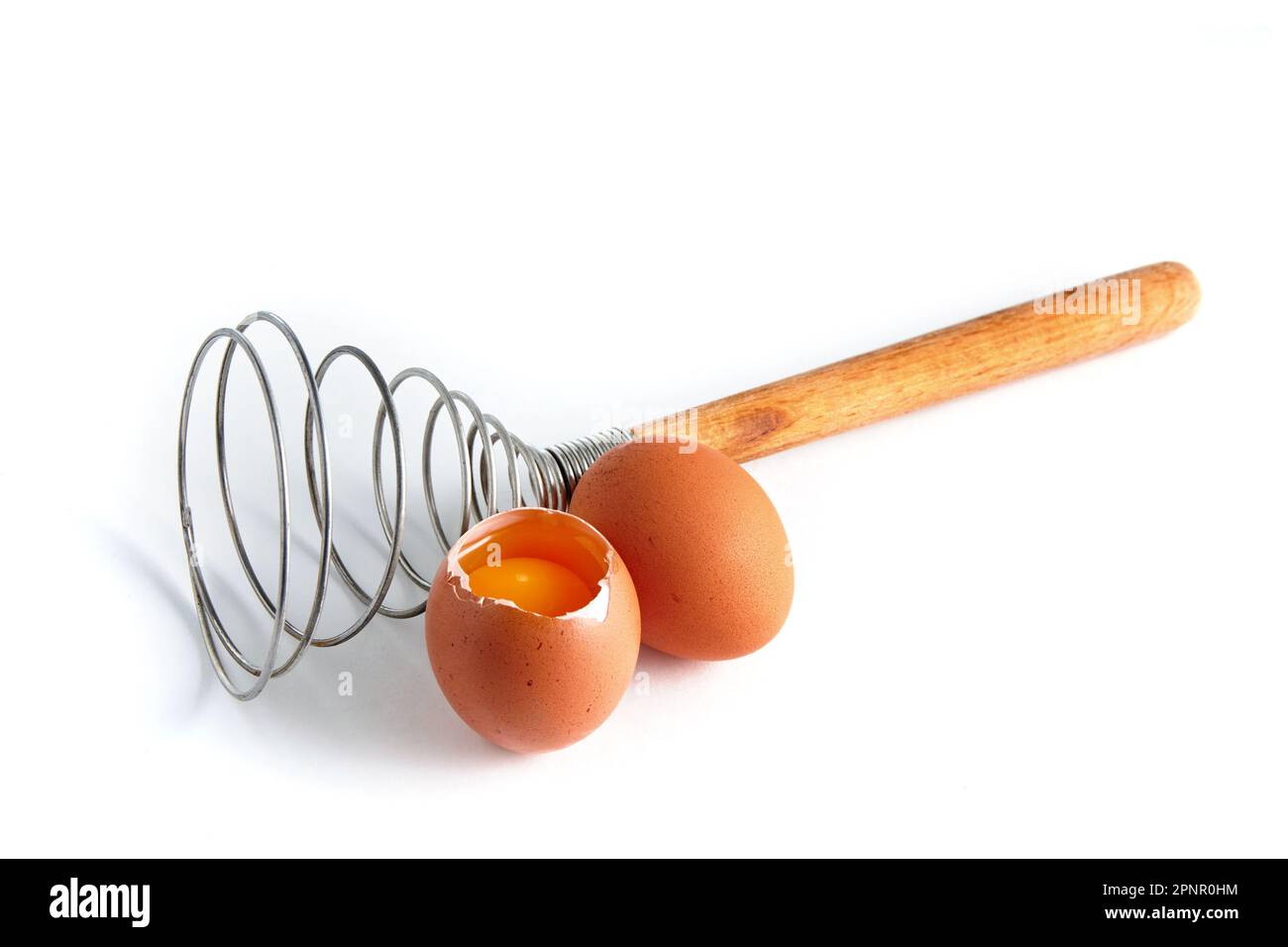 Two beige chicken eggs and a rare beater for beating. Cooking ...