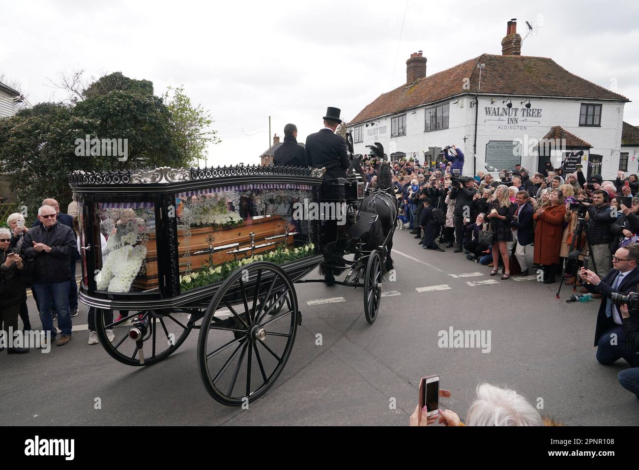 The funeral cortege of Paul O'Grady travels through the village of ...