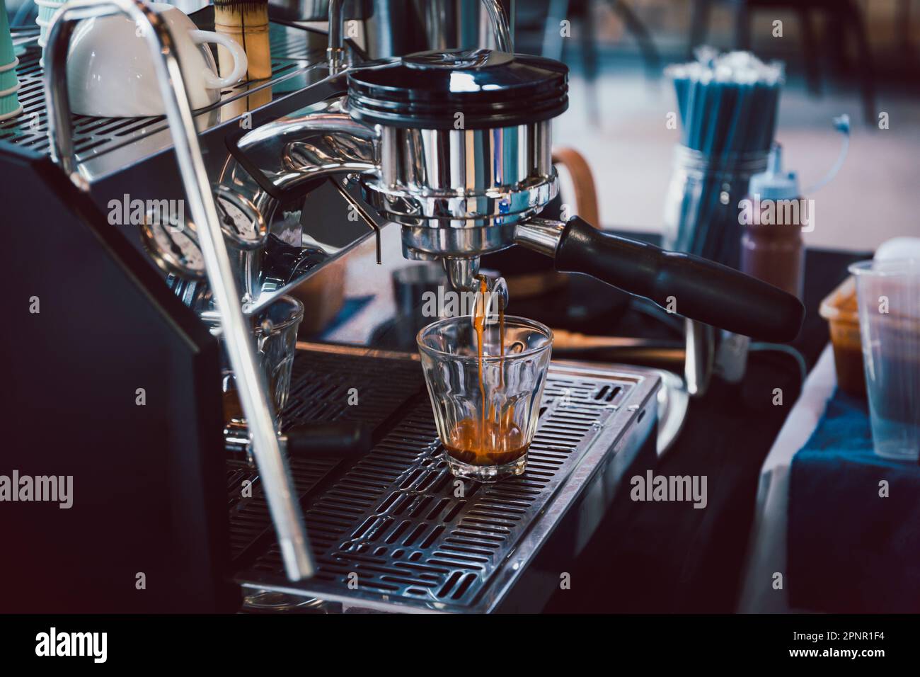 Espresso machine pouring coffee into glass in cafe Stock Photo - Alamy