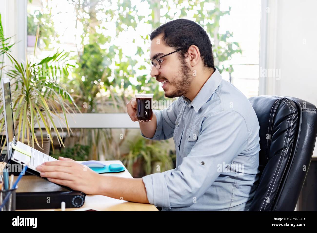 A successful looking business man drinking coffee while working at a ...