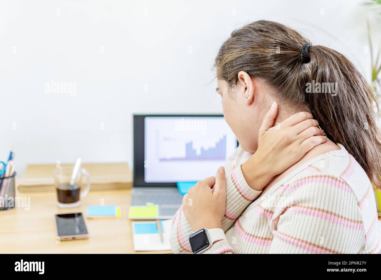 A woman stretching and exercising in an office setting, seeking relief ...