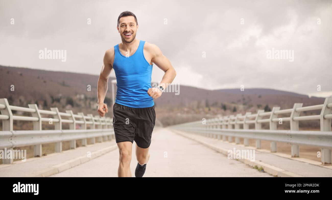 Fit man running on a cloudy day Stock Photo - Alamy