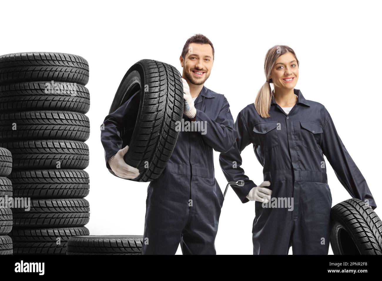 Male and female auto mechanic workers with piles of tires isolated on ...