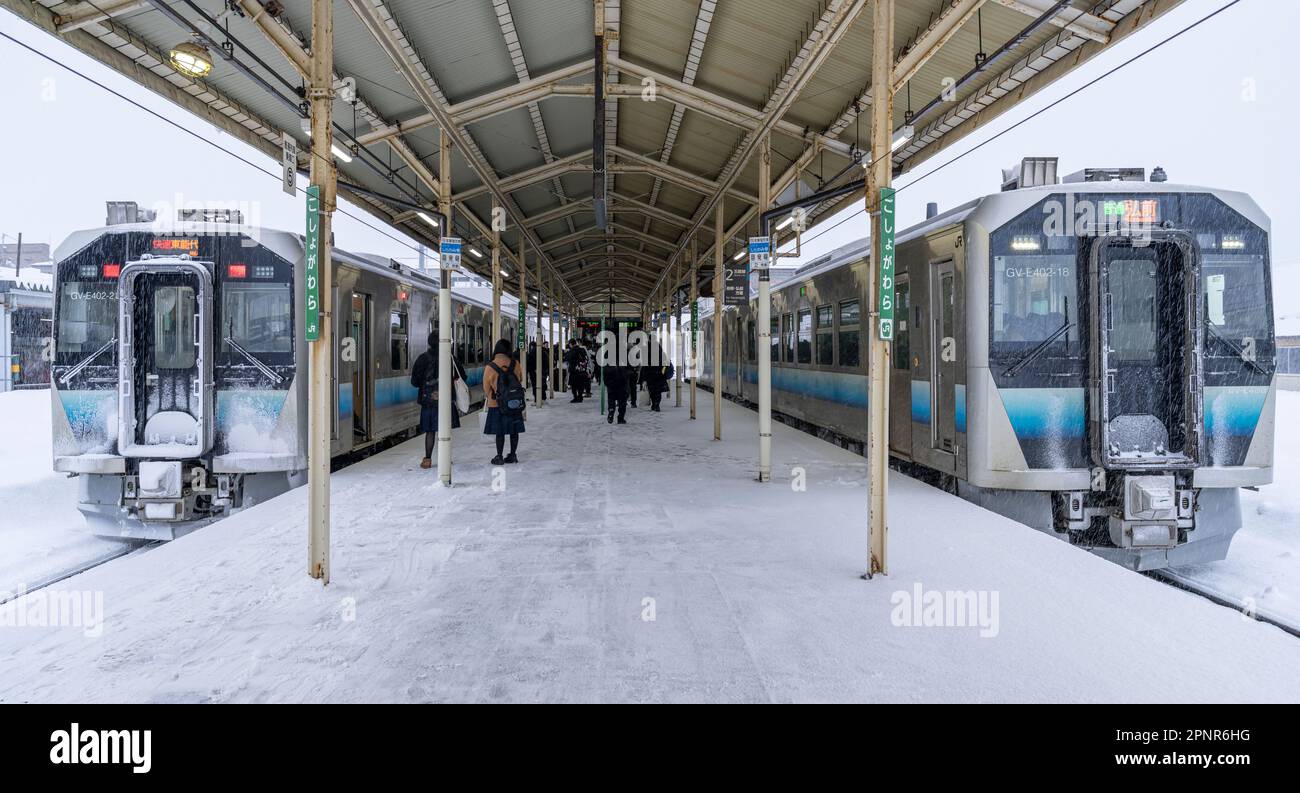 JR East GV-E400 series trains on a snowy day at Goshogawara Station in ...