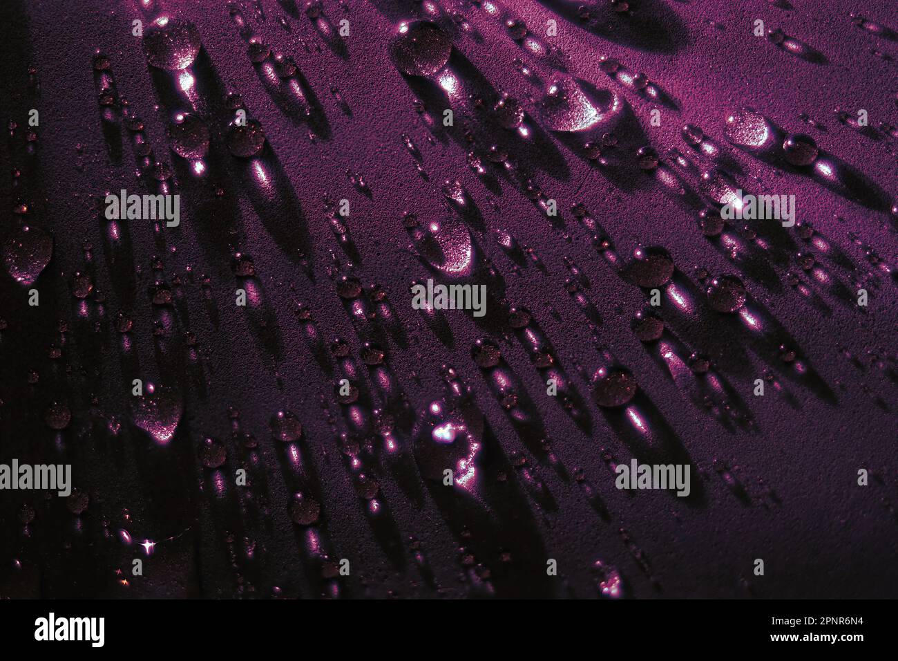 Round drops of water on dark background. Through transparent drops of ...