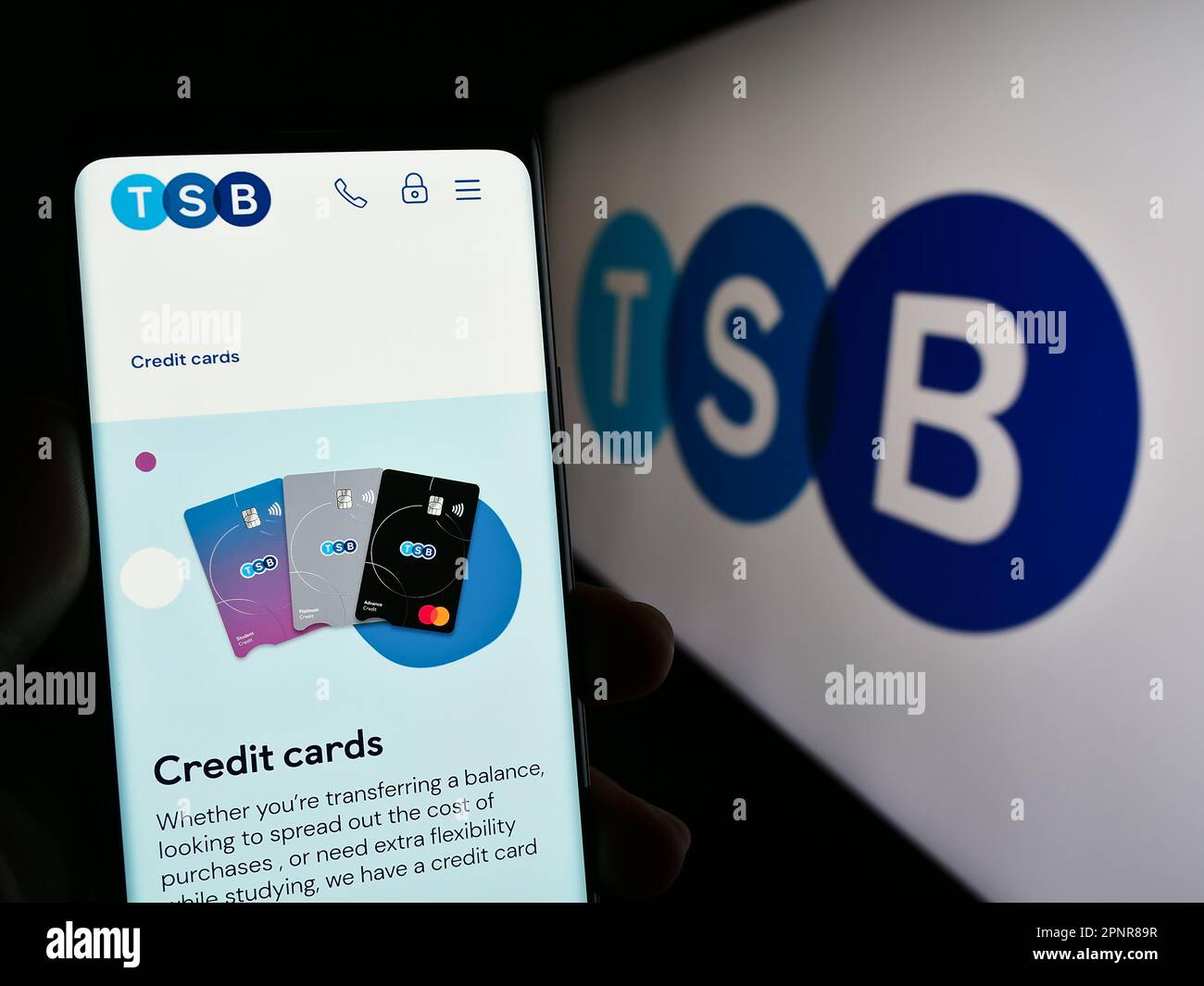 Person holding smartphone with web page of British financial company ...