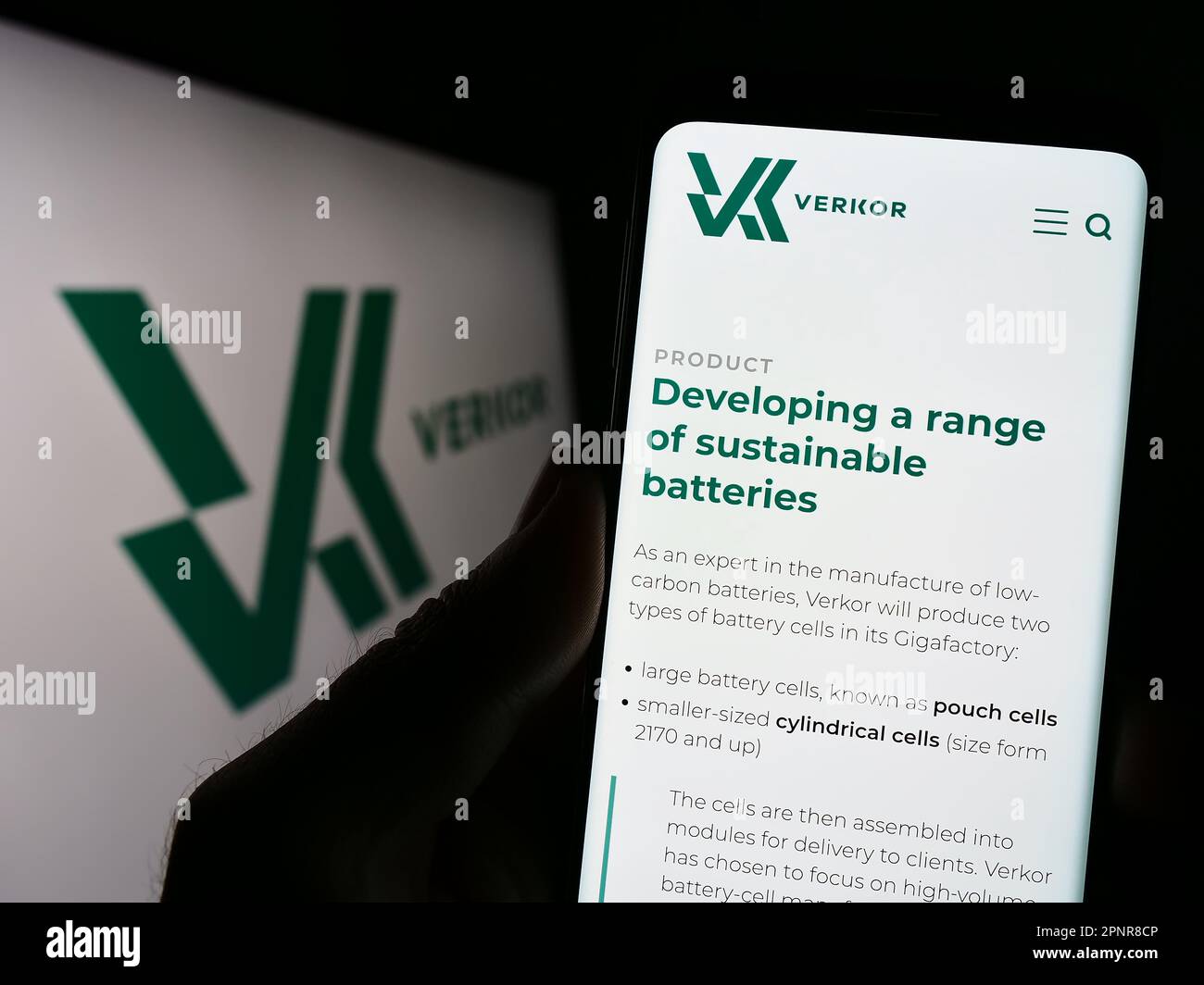 Person holding cellphone with webpage of French battery company Verkor ...