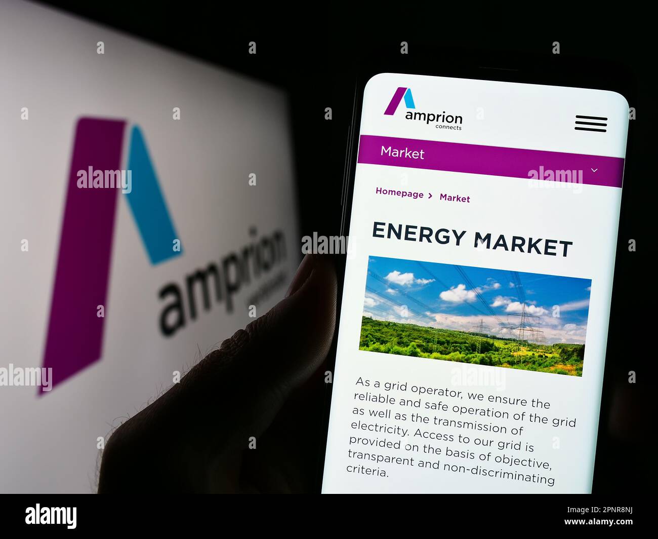 Person holding cellphone with webpage of German TSO company Amprion ...