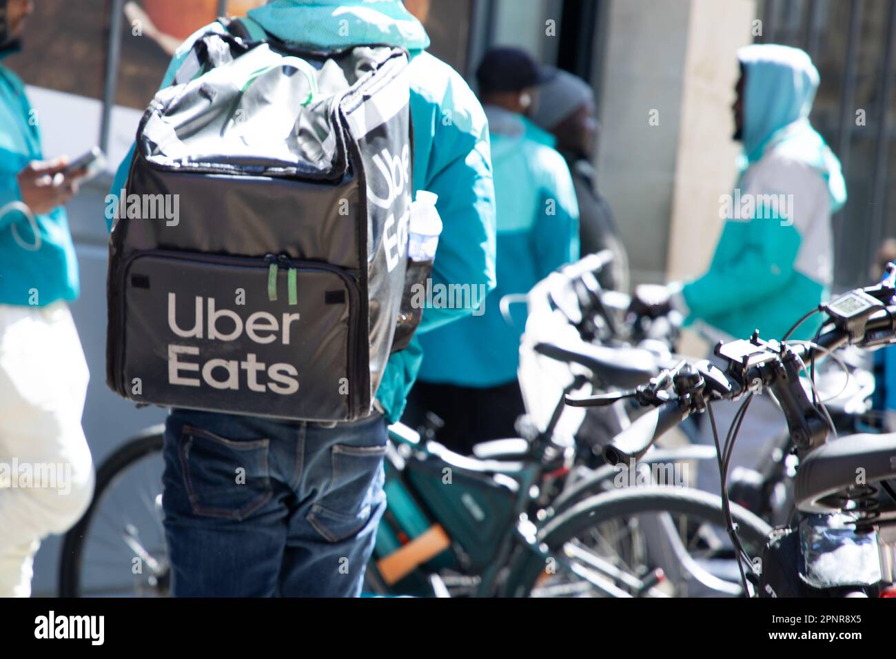 Bordeaux , Aquitaine France - 04 17 2023 : Uber eats delivery man group on bike ride on city ...