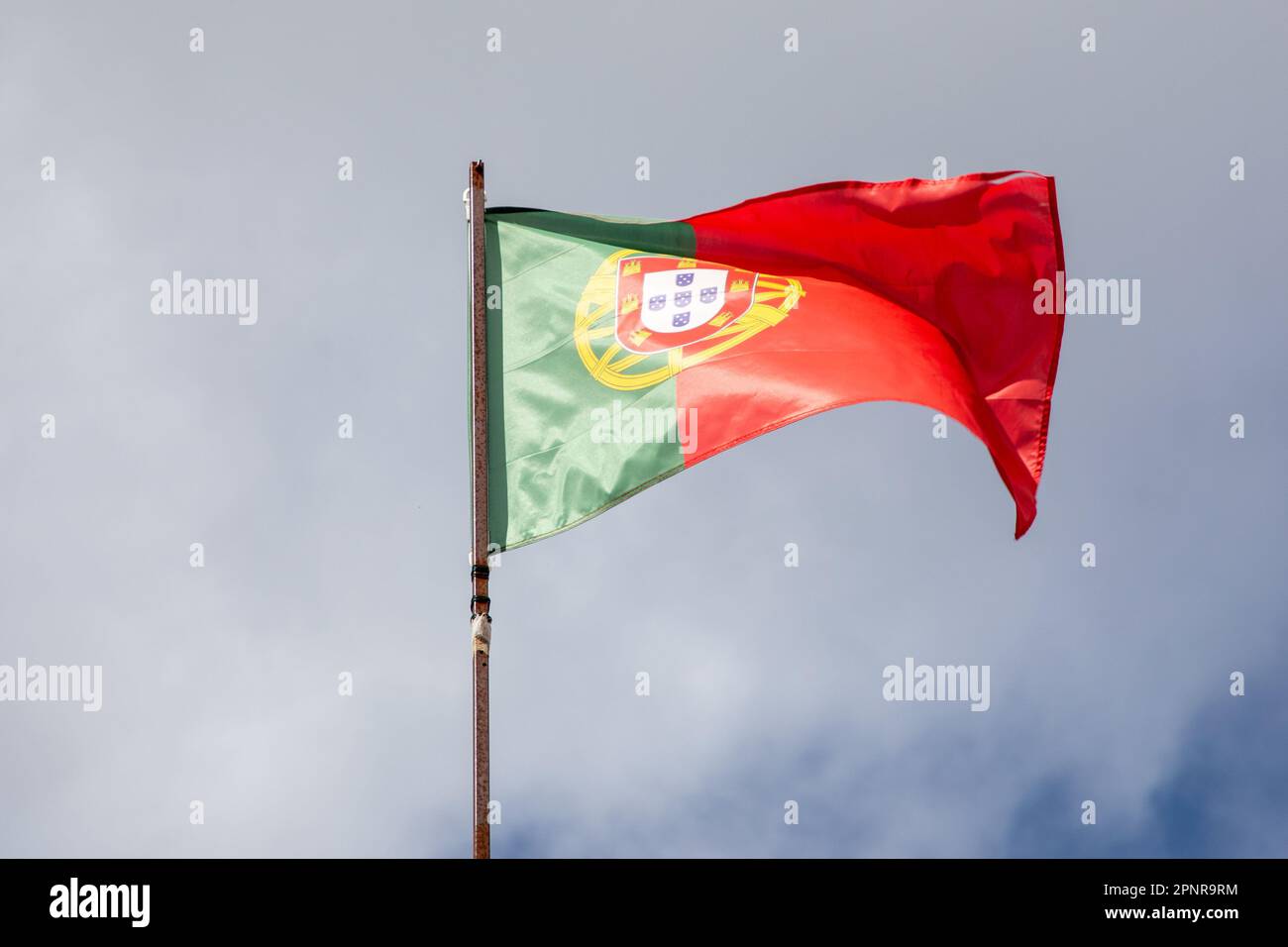 Flag of Portugal waving over cloud blue Portuguese sky Stock Photo - Alamy