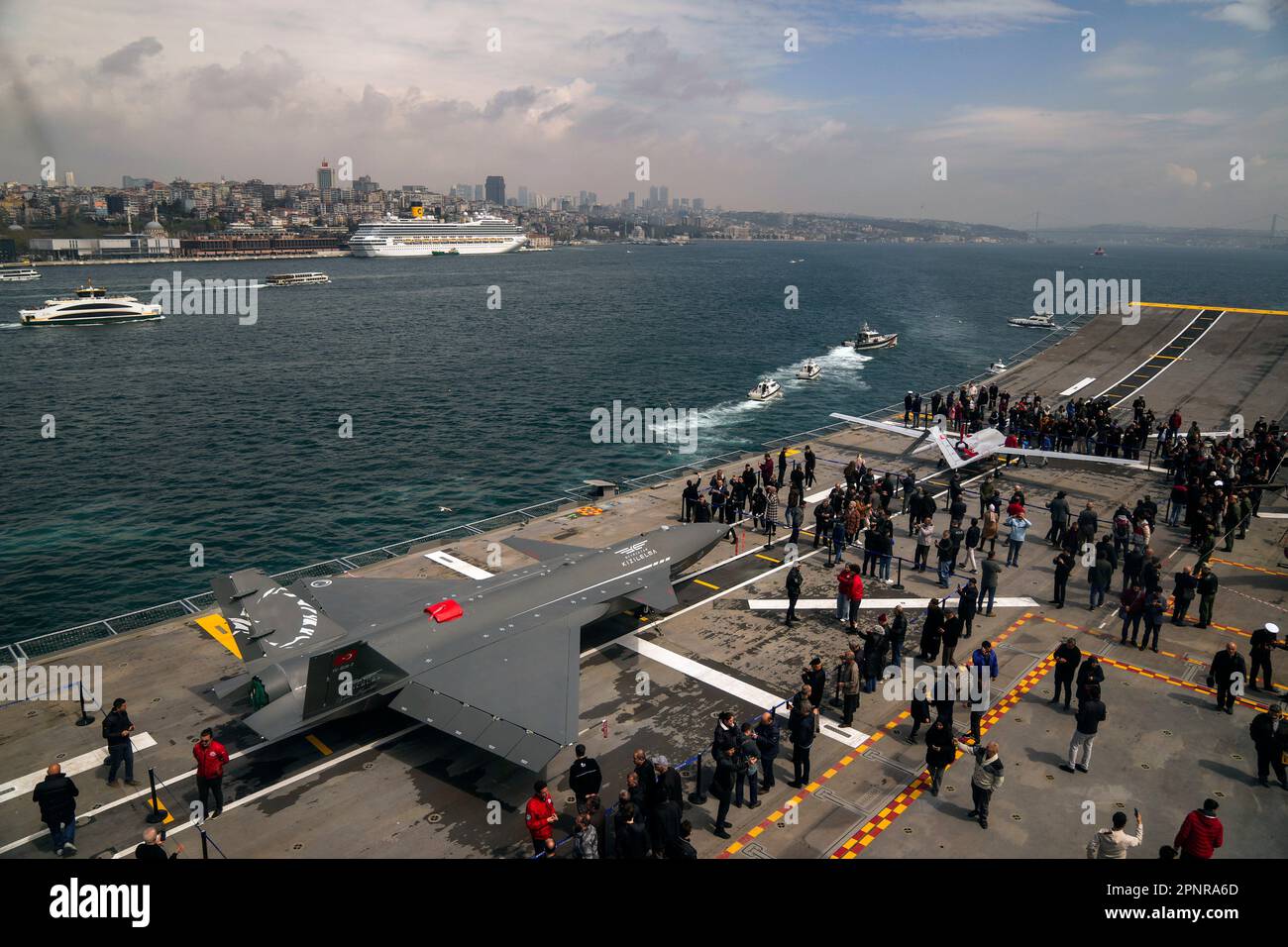 People stand next to unmanned combat aerial vehicles (UCAV) Bayraktar TB3, right, and Bayraktar ...