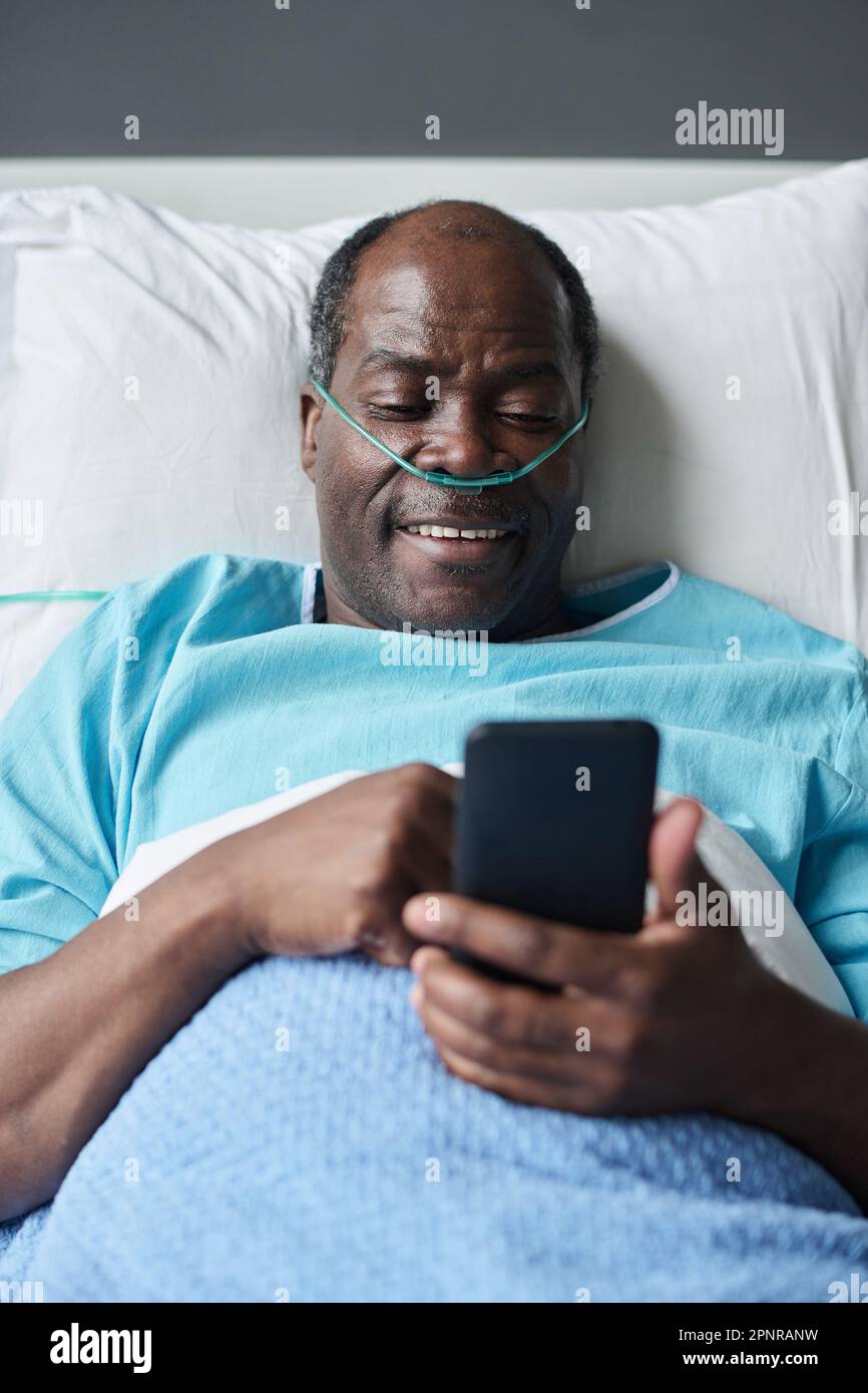 Vertical image of elderly patient having video call on smartphone while ...