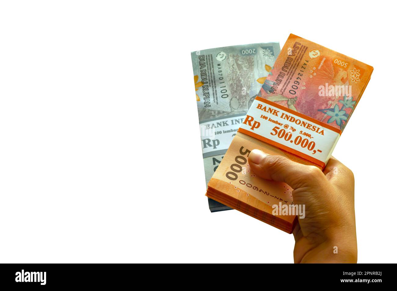 An Asian child holds Indonesian money in shallow focus. Saving, charity ...