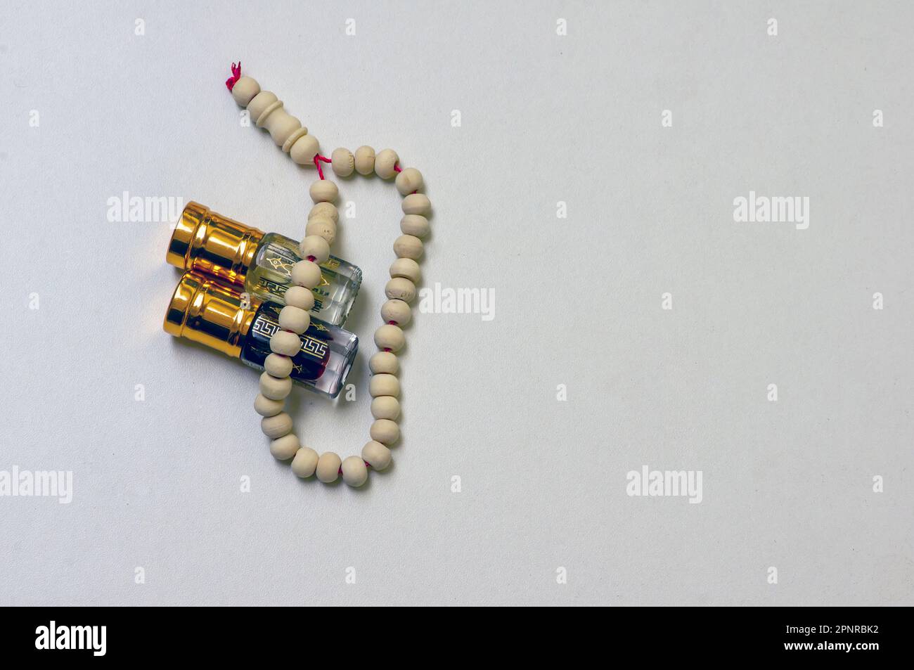 Top view of perfume bottle and prayer beads, on white background Stock ...