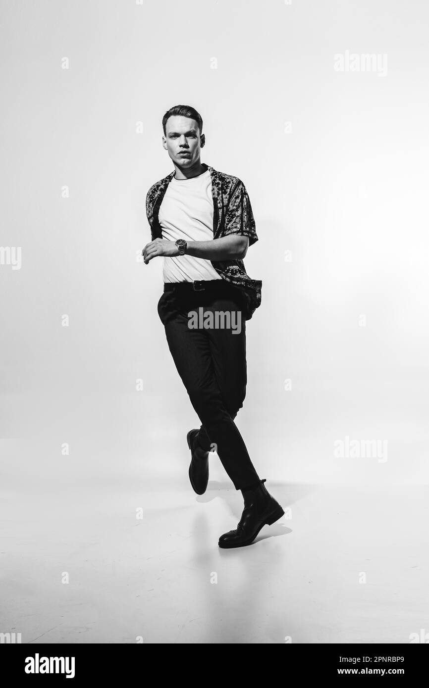 An elegant man runs with high class in front of a studio cyclorama ...