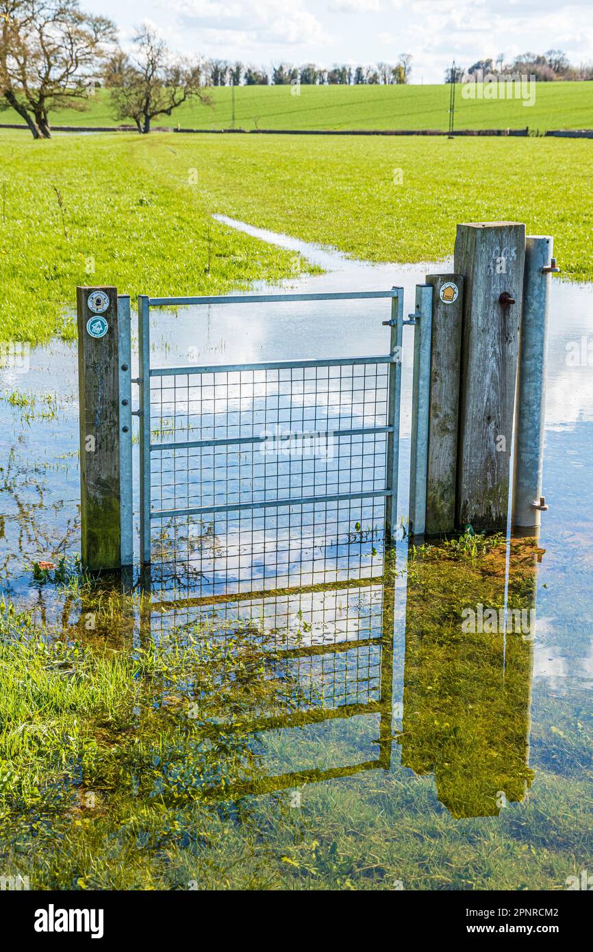 A field gate on the Thames Path National Trail under water after rain ...