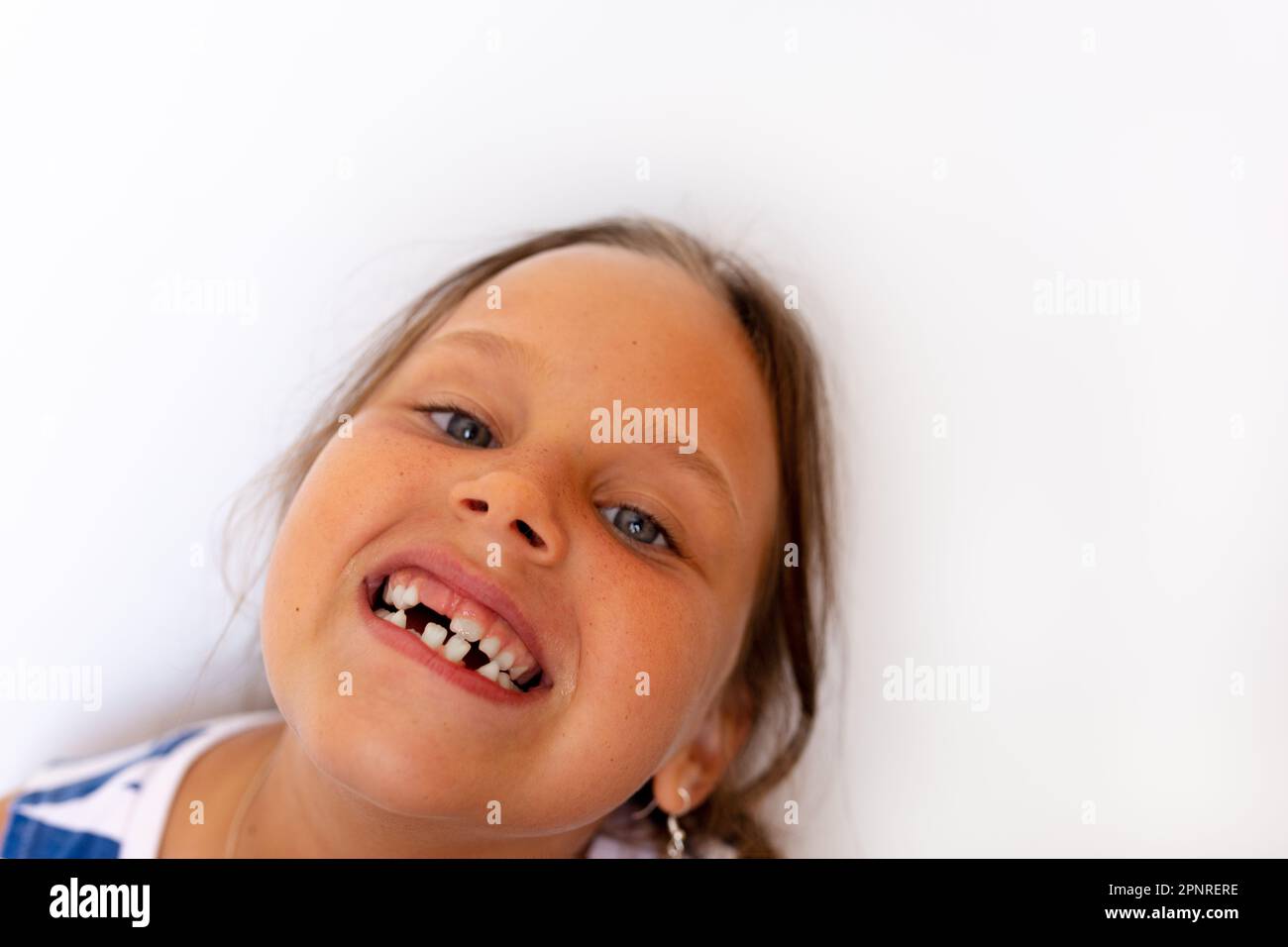 Toothless smiling, funny, grimacing blonde girl with temporary milk ...