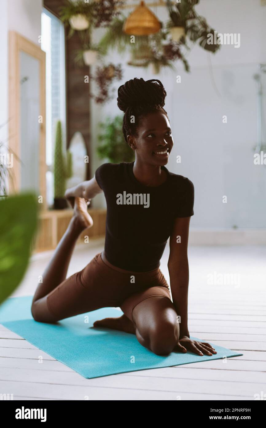 Beautiful And Athletic Afro American Woman Sitting And Pulling Bent